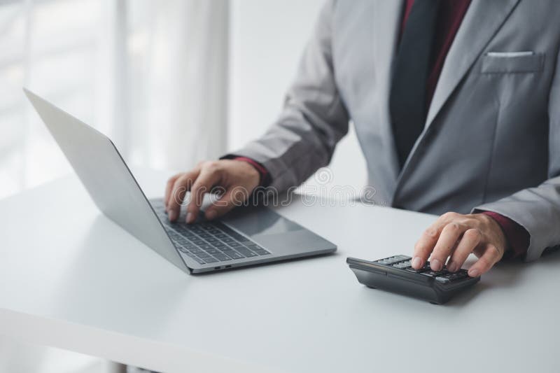 Businessman Using a Calculator To Calculate Numbers on a Company S ...