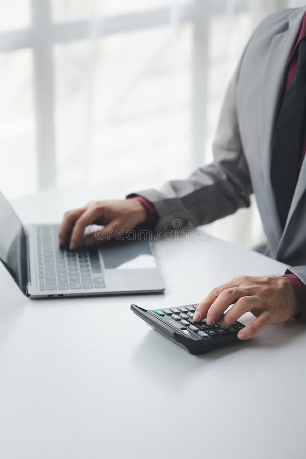 Businessman Using a Calculator To Calculate Numbers on a Company S ...