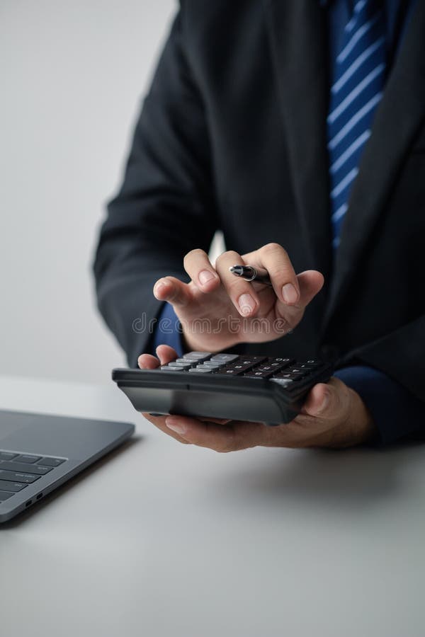 Businessman Using a Calculator To Calculate Numbers on a Company S ...