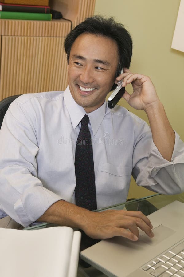 Businessman Using Cell Phone and Laptop at Work Stock Image - Image of ...