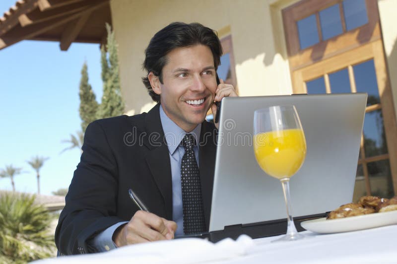 Businessman Using Cell Phone while Writing Notes Stock Image - Image of ...