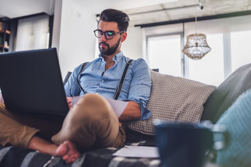 Man Working on Laptop Computer while Sitting on Sofa Stock Photo ...
