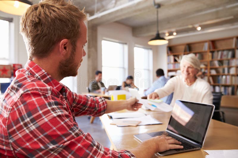 Businessman Using Laptop at Desk in Busy Office Stock Image - Image of ...