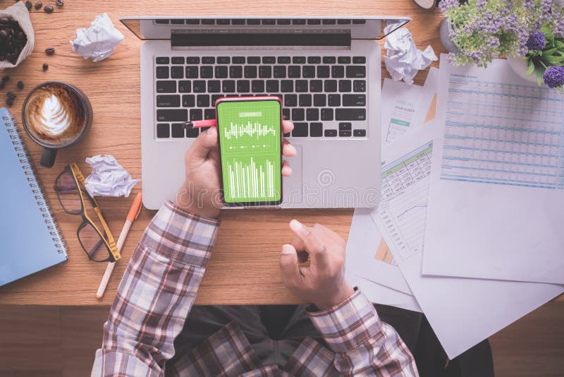 Businessman Using Mobile Phone with Mock Up Chart Report on Screen ...