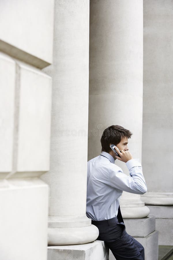 Businessman Using Mobile Phone by Pillar Stock Photo - Image of pillar ...