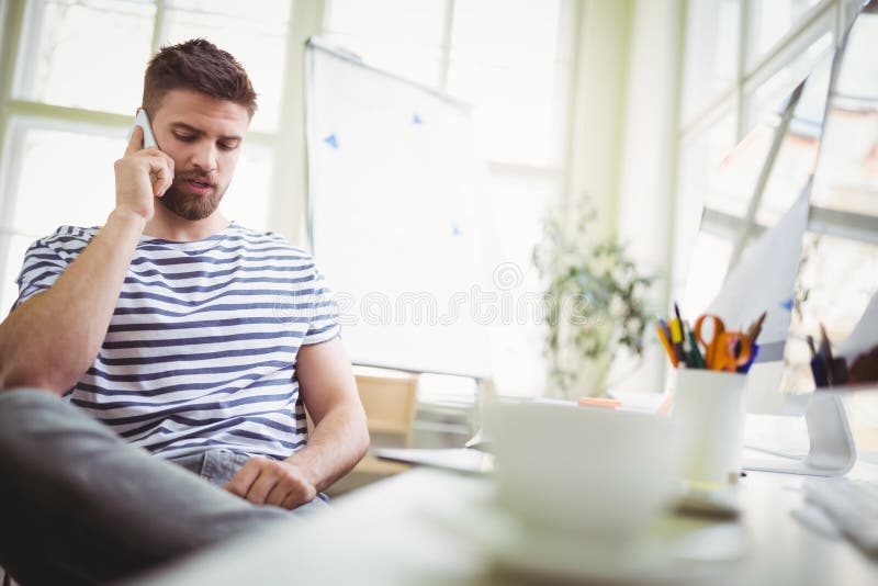 Businessman Using Mobile Phone while Sitting in Office Stock Image ...