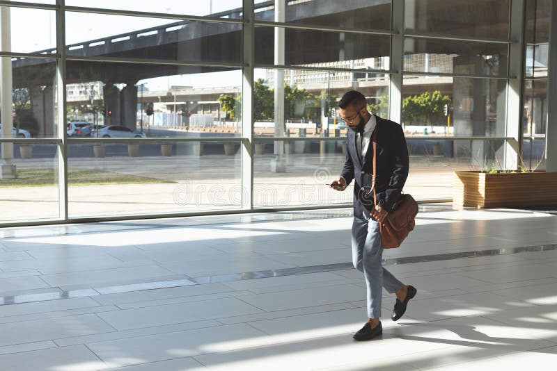 Businessman Using Mobile Phone while Walking in Lobby Office Stock ...