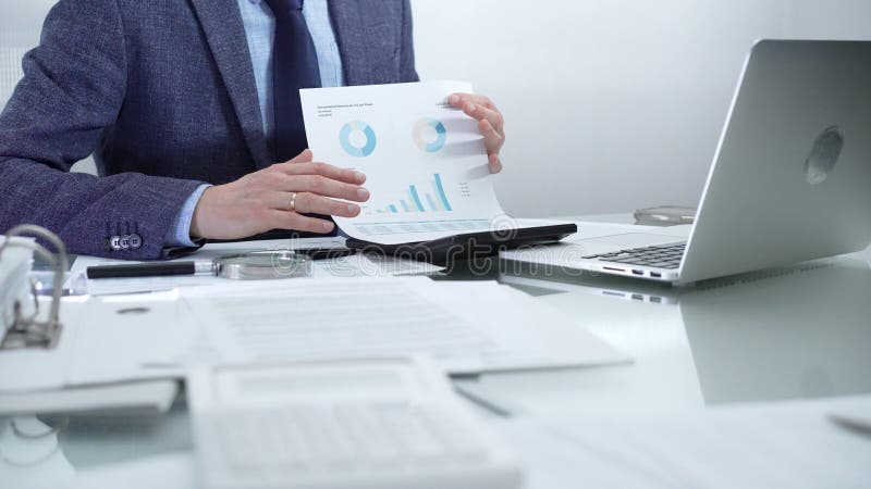Businessman Wearing Blue Suit is Working with Laptop while Examining ...