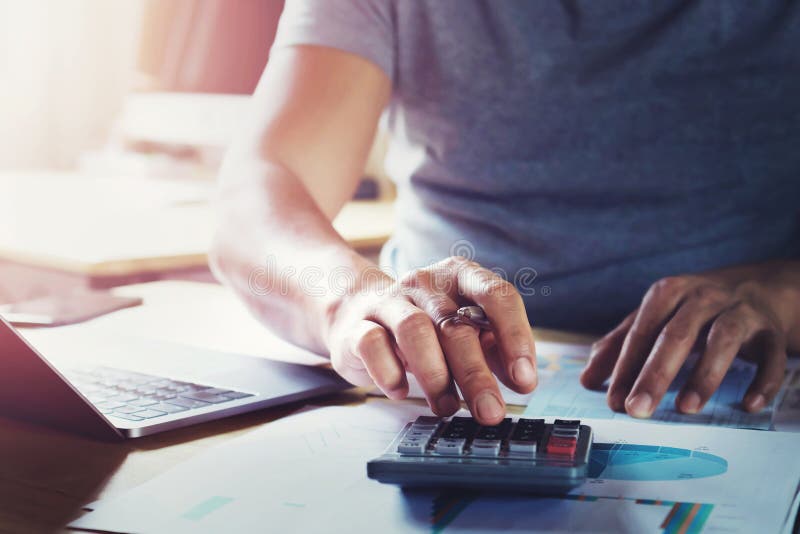 Businessman Working on Desk Using Calculator To Calculate Data of ...