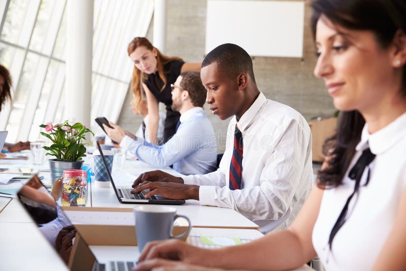 Businessman Working on Laptop in Busy Office Stock Photo - Image of ...