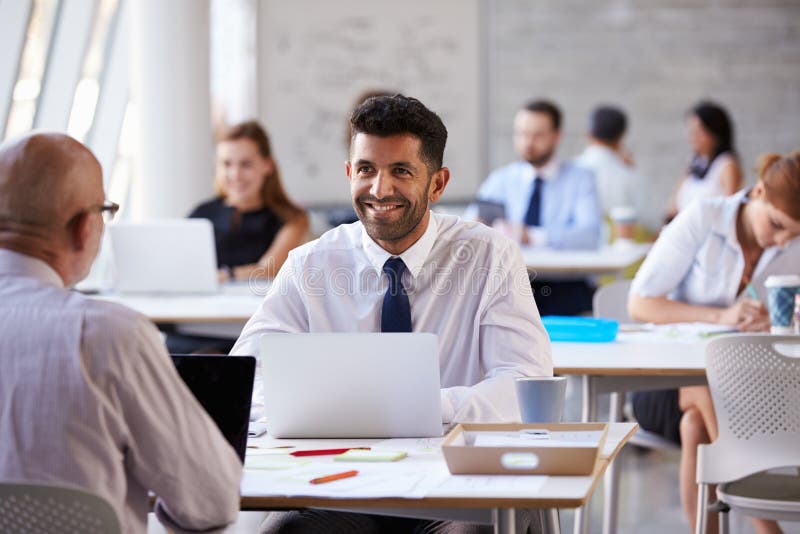 Businessman Working on Laptop in Busy Office Stock Image - Image of ...