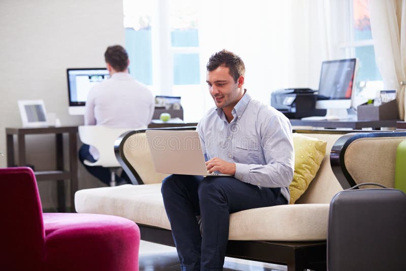 Businessman Working on Laptop in Hotel Lobby Stock Image - Image of ...