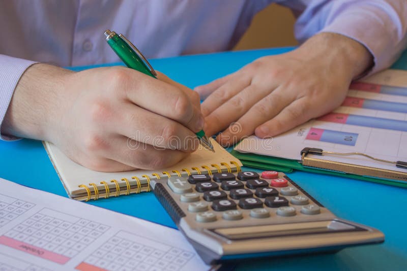 Businessman Working on Office Desk with Calculator, a Pen and Document ...
