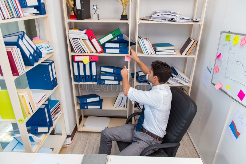 Businessman Working in the Office with Piles of Books and Papers Stock ...