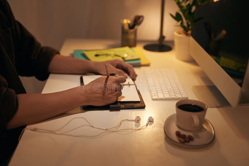 A Businessman Writing Notes on a Writing Pad while Sitting at His ...