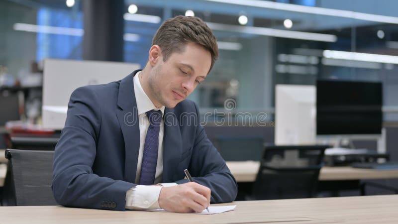 Businessman Writing on Paper in Office Stock Image - Image of journal ...