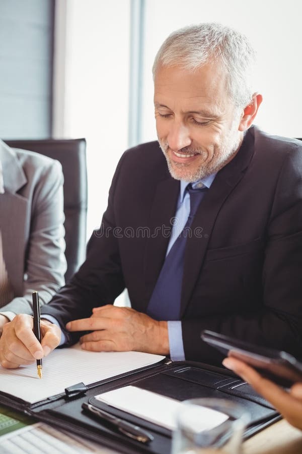 Businessman Writing a Report in Conference Room Stock Photo - Image of ...