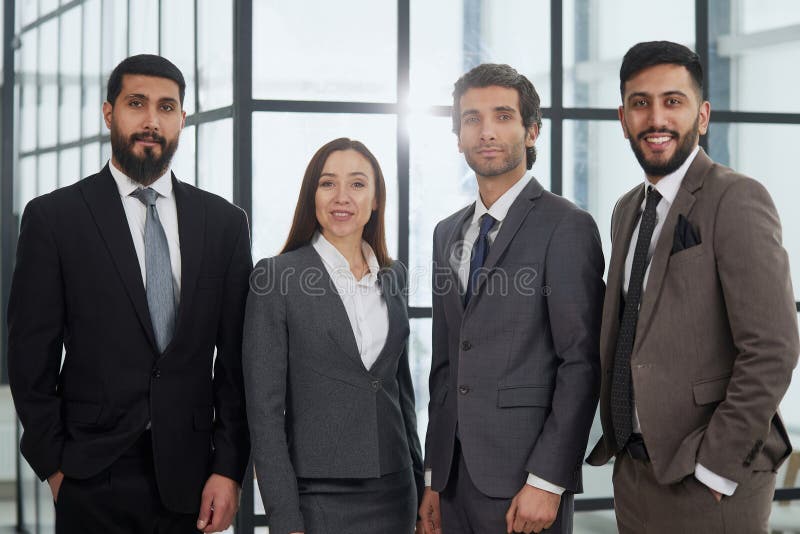 Businessmen with Brunette in Group Posing in Office Lobby Stock Photo ...