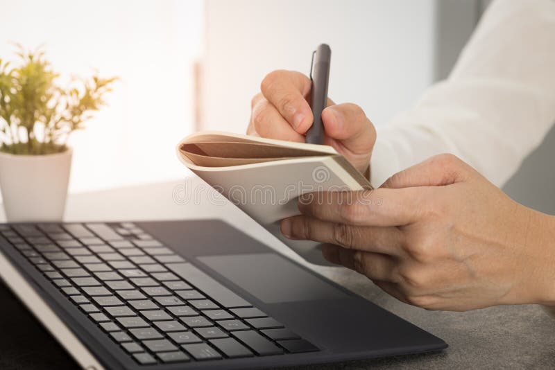 Businessmen Holding a Pen and Writing a Note in a Notebook. Stock Photo ...