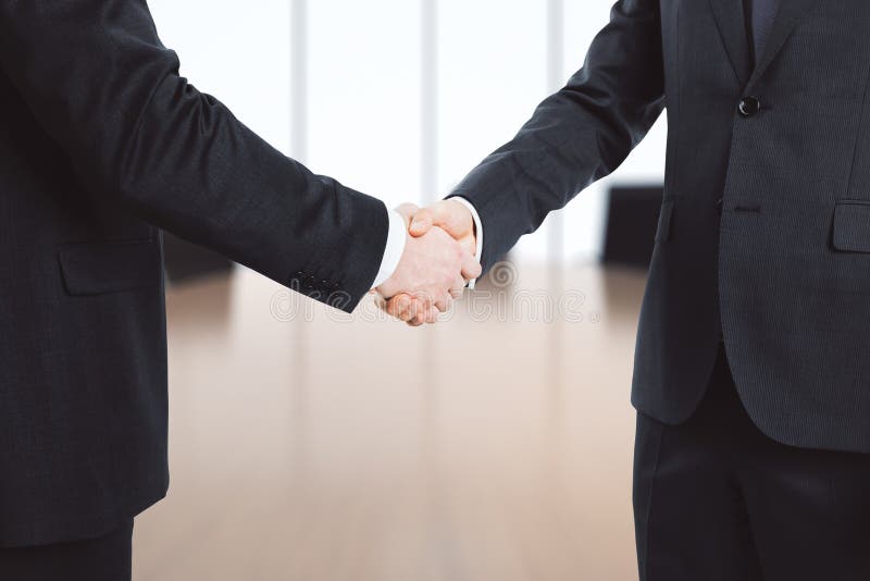 Businessmen Shake Hands in Loft Office with Blank White Wall, Mo Stock ...