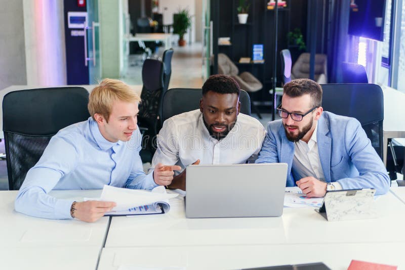 Businessmen Sitting at the Office Table and Comparing Data from Report ...