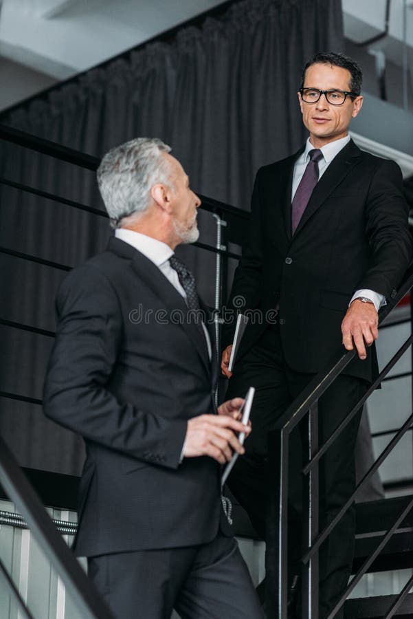 Businessmen in Suits Having Conversation while Going Down on Steps ...