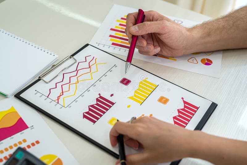 Businesspartners during Discussion of Papers, Graph on Desk Stock Photo ...