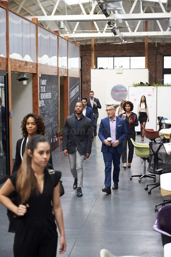 Businesspeople Arriving for Work in Busy Modern Open Plan Office Stock ...