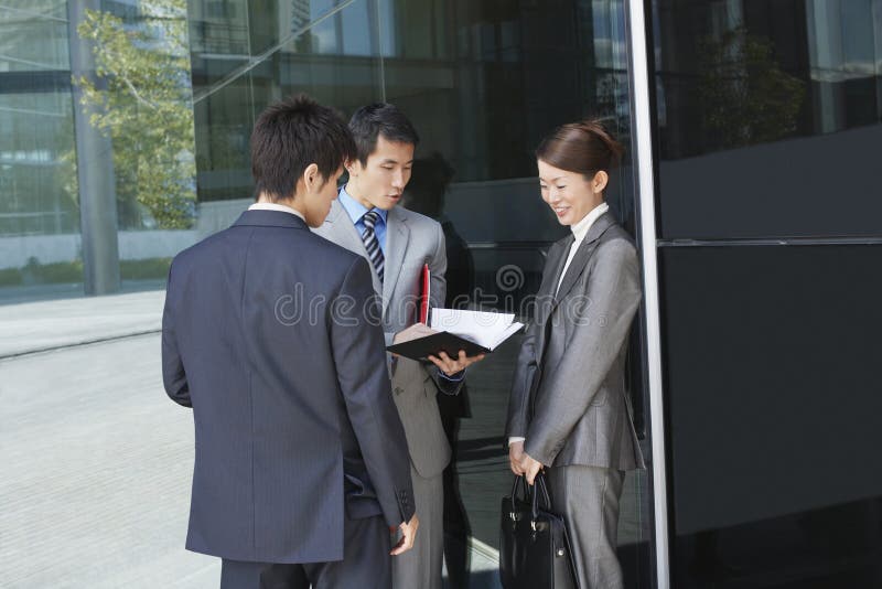 Businesspeople Looking through Documents Outdoors Stock Image - Image ...