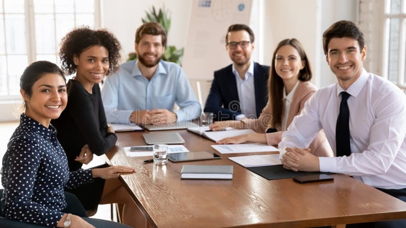 Businesspeople Posing for Camera Gathered Together at Conference Table ...