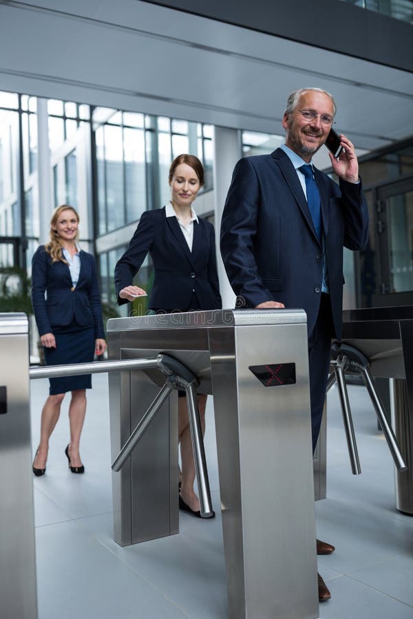 Businesspeople Scanning Their Cards at Turnstile Gate Stock Image ...