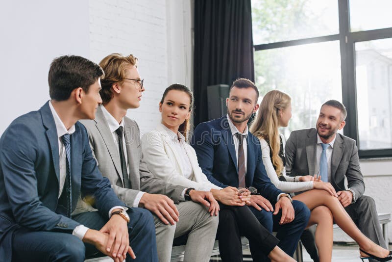 Businesspeople Sitting on Chairs in Row during Training Stock Photo ...
