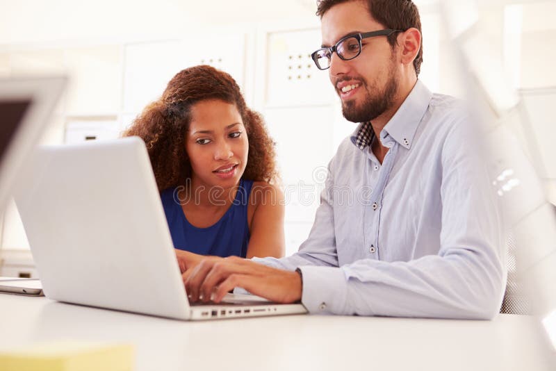 Businesspeople Using Laptop in Office of Start Up Business Stock Photo ...