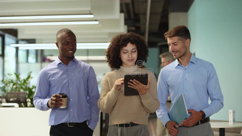 Businesspeople Walking and Talking about Work in Office Corridor Stock ...