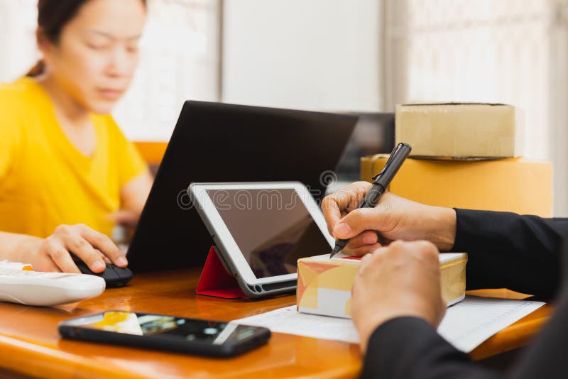 Businesspeople Writing Address on Parcel Box with Woman Partner Using ...