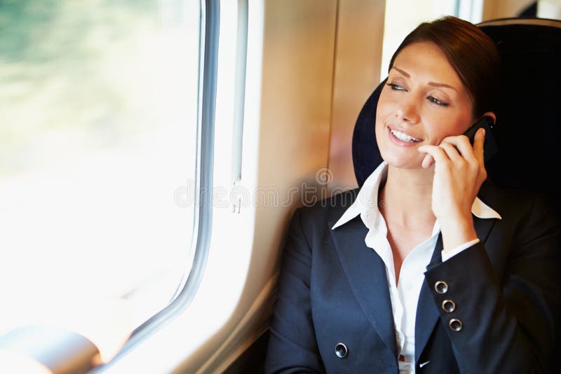 Businesswoman Commuting To Work on Train Using Mobile Phone Stock Photo ...