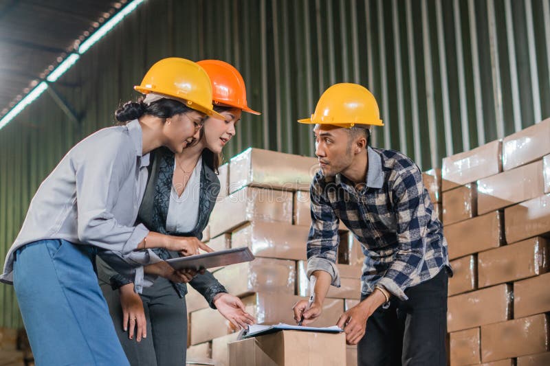 Businesswoman Corrects the Work of Two Factory Workers during Visit ...