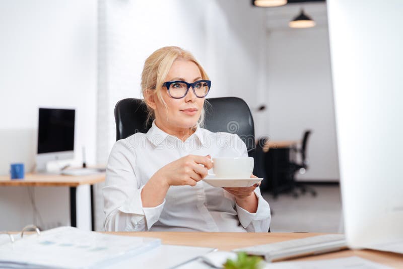Businesswoman Drinking Coffee with Computer at Office Stock Photo ...