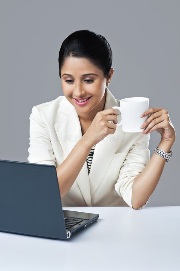 Businesswoman Drinking Coffee and Looking at Laptop Stock Image - Image ...