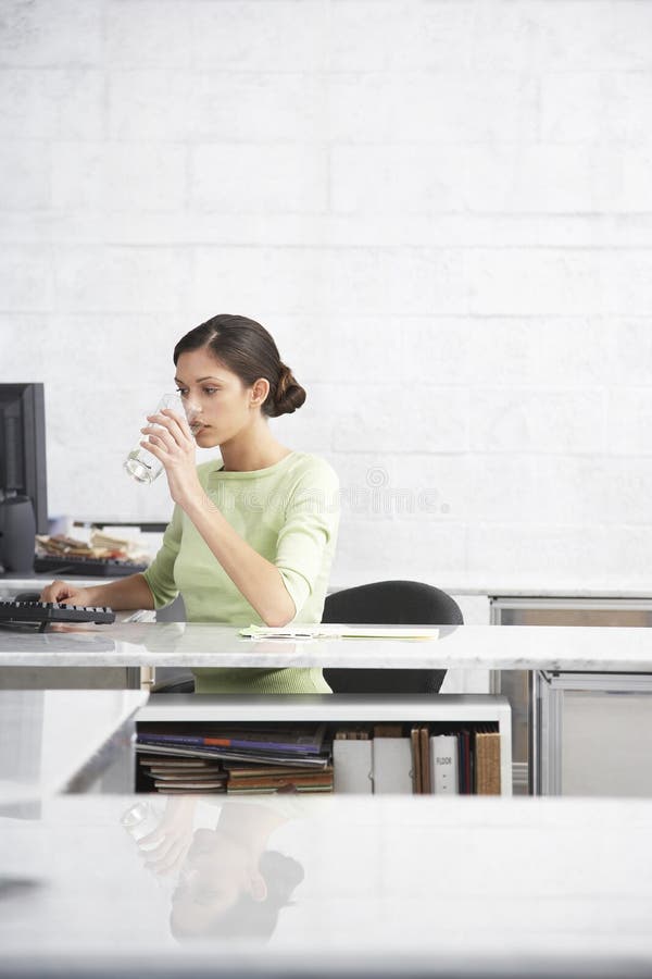 Focused Businesswoman Drinking a Glass of Water at Her Desk Stock Photo ...