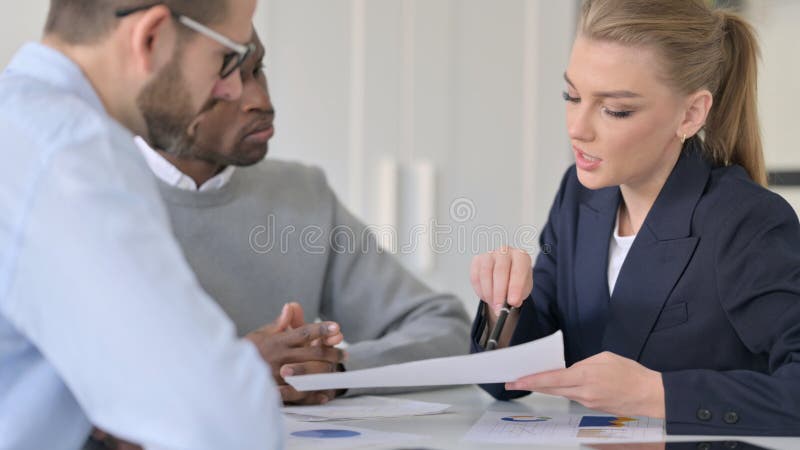 Businesswoman Explaining Documents To Male Colleagues Stock Image ...