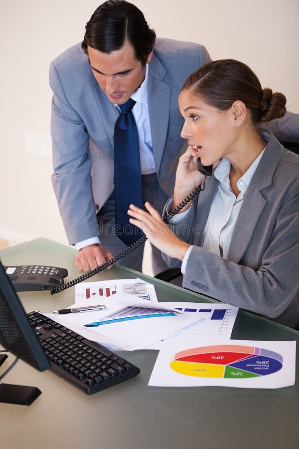 Businesswoman Getting a Phone Call while Analyzing Statistics Stock ...