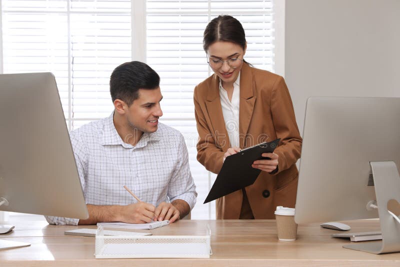 Businesswoman Helping Intern with Work in Office Stock Photo - Image of ...