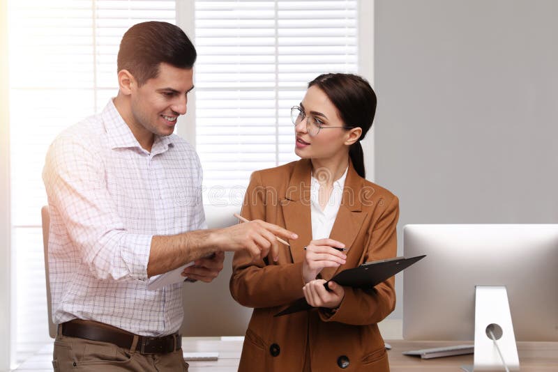 Businesswoman Helping Intern with Work in Office Stock Photo - Image of ...