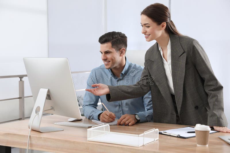 Businesswoman Helping Intern with Work in Office Stock Image - Image of ...