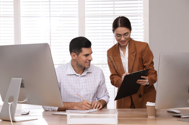 Businesswoman Helping Intern with Work in Office Stock Image - Image of ...