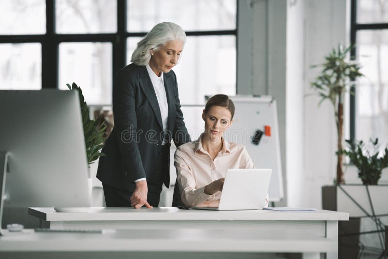 Businesswoman and Her Boss Working with Laptop Computer in Office Stock ...