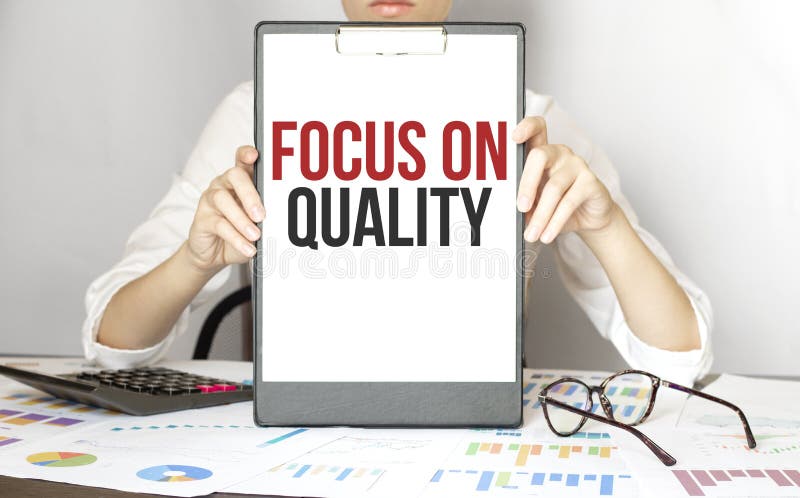 Businesswoman Holding a Card with Text FOCUS on QUALITY Stock Photo ...