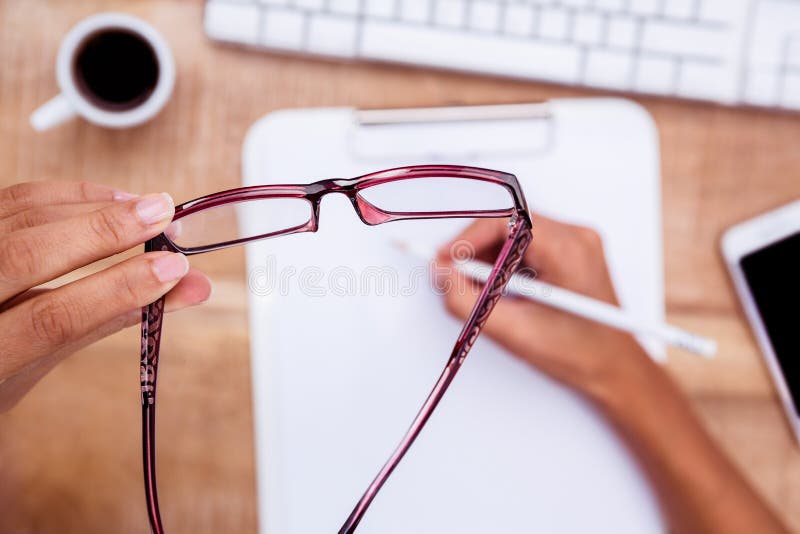 Businesswoman Holding Eye Glasses Stock Image - Image of beverage, desk ...