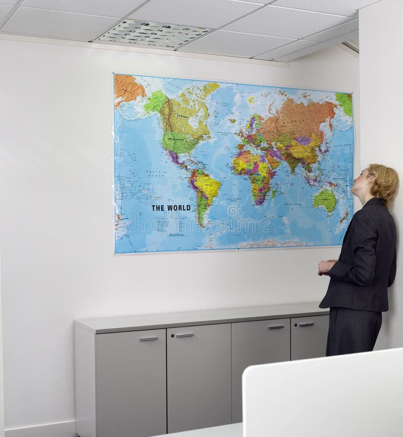 Businesswoman Looking at World Map in Office Stock Photo - Image of ...
